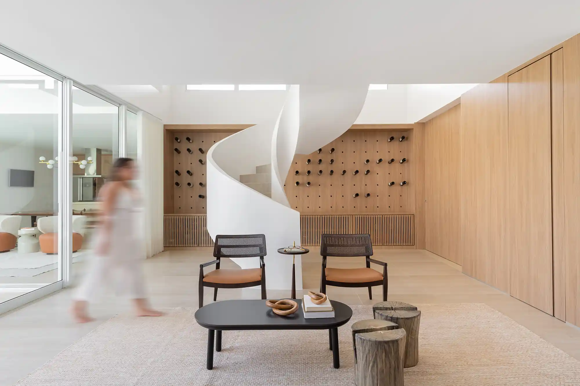 Adega e escada helicoidal se destacam em casa com projeto atemporal